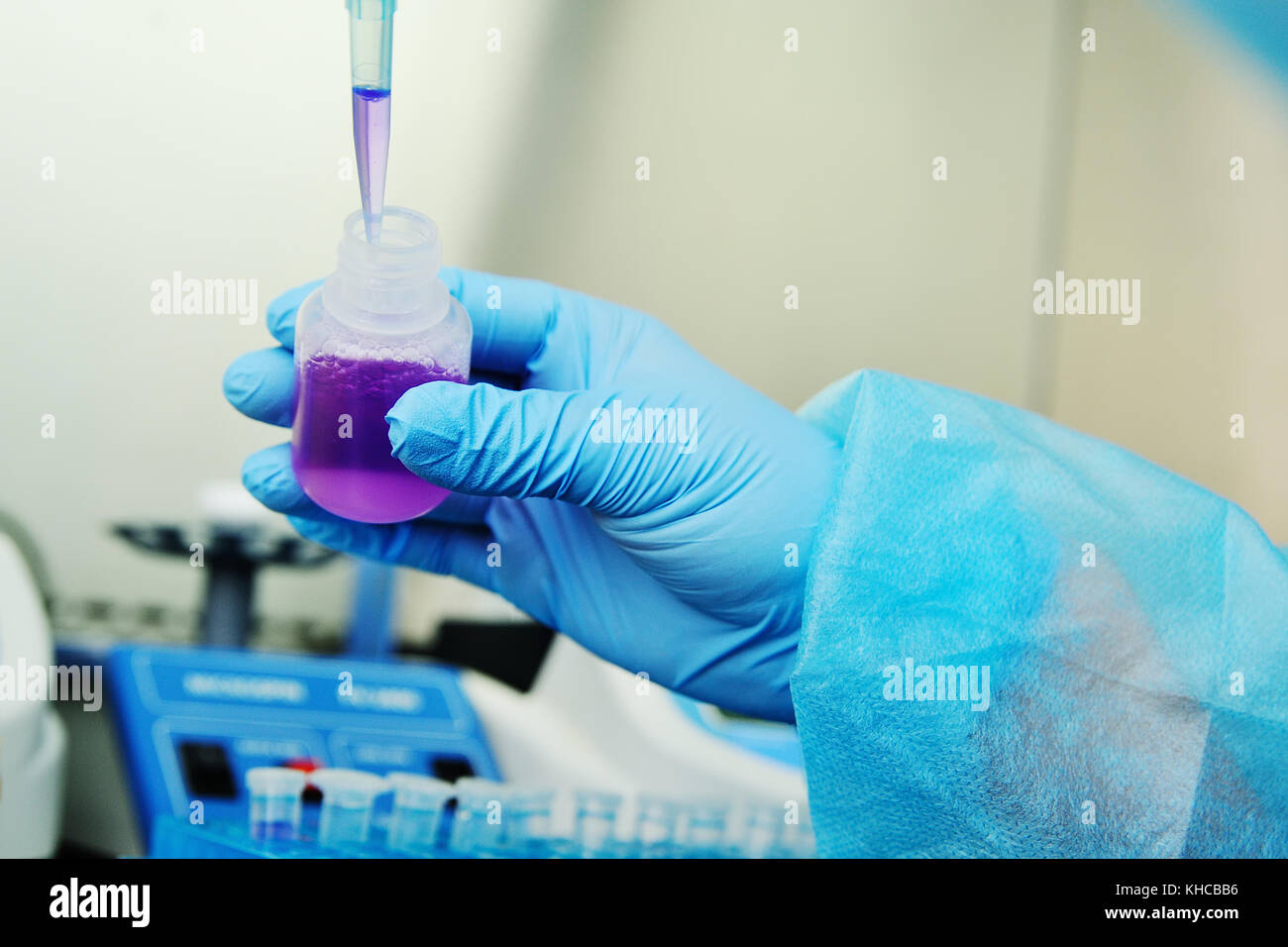A laboratory scientist with a dispenser in his hands conducts ...
