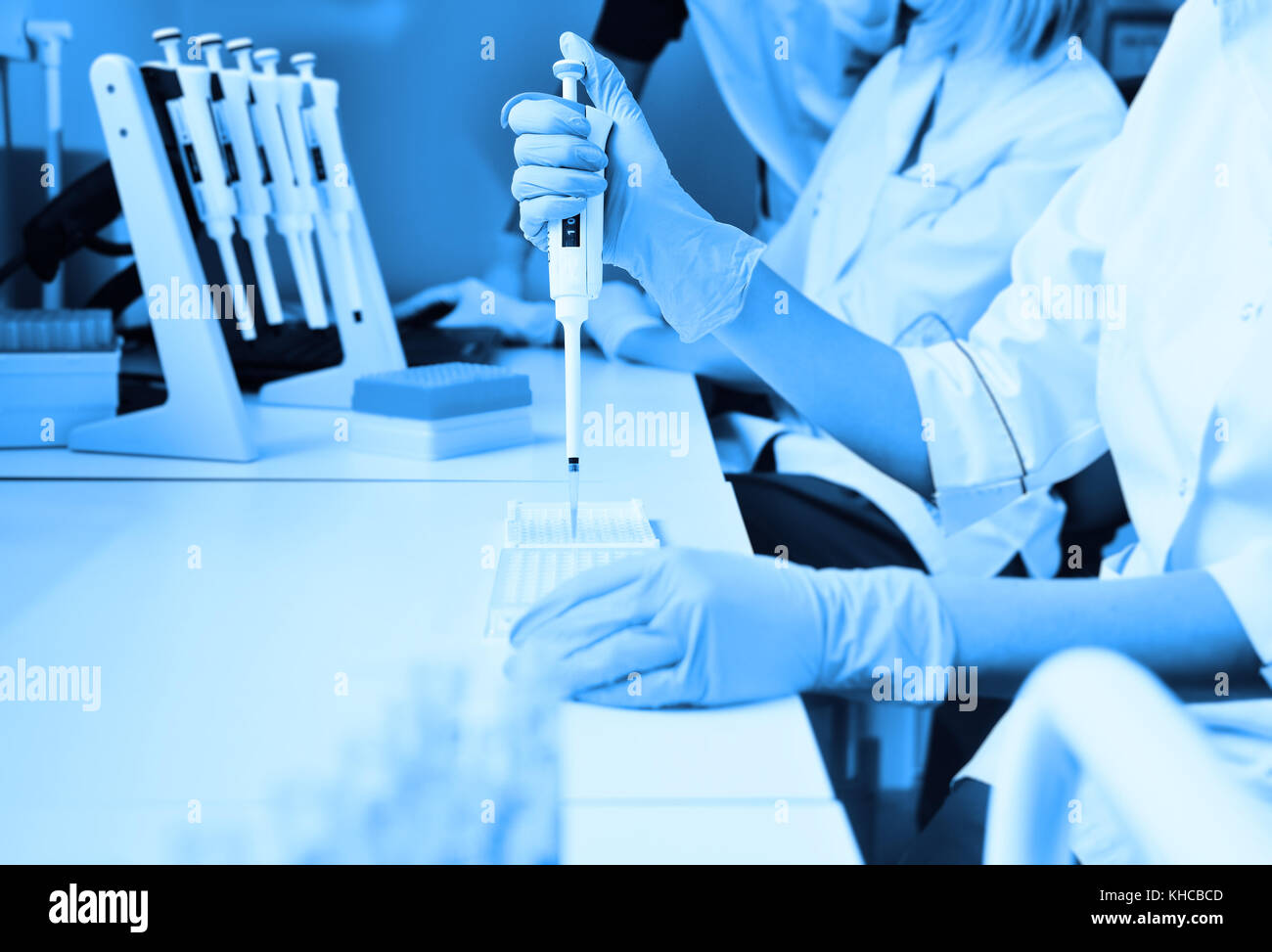 A laboratory scientist with a dispenser in his hands conducts ...