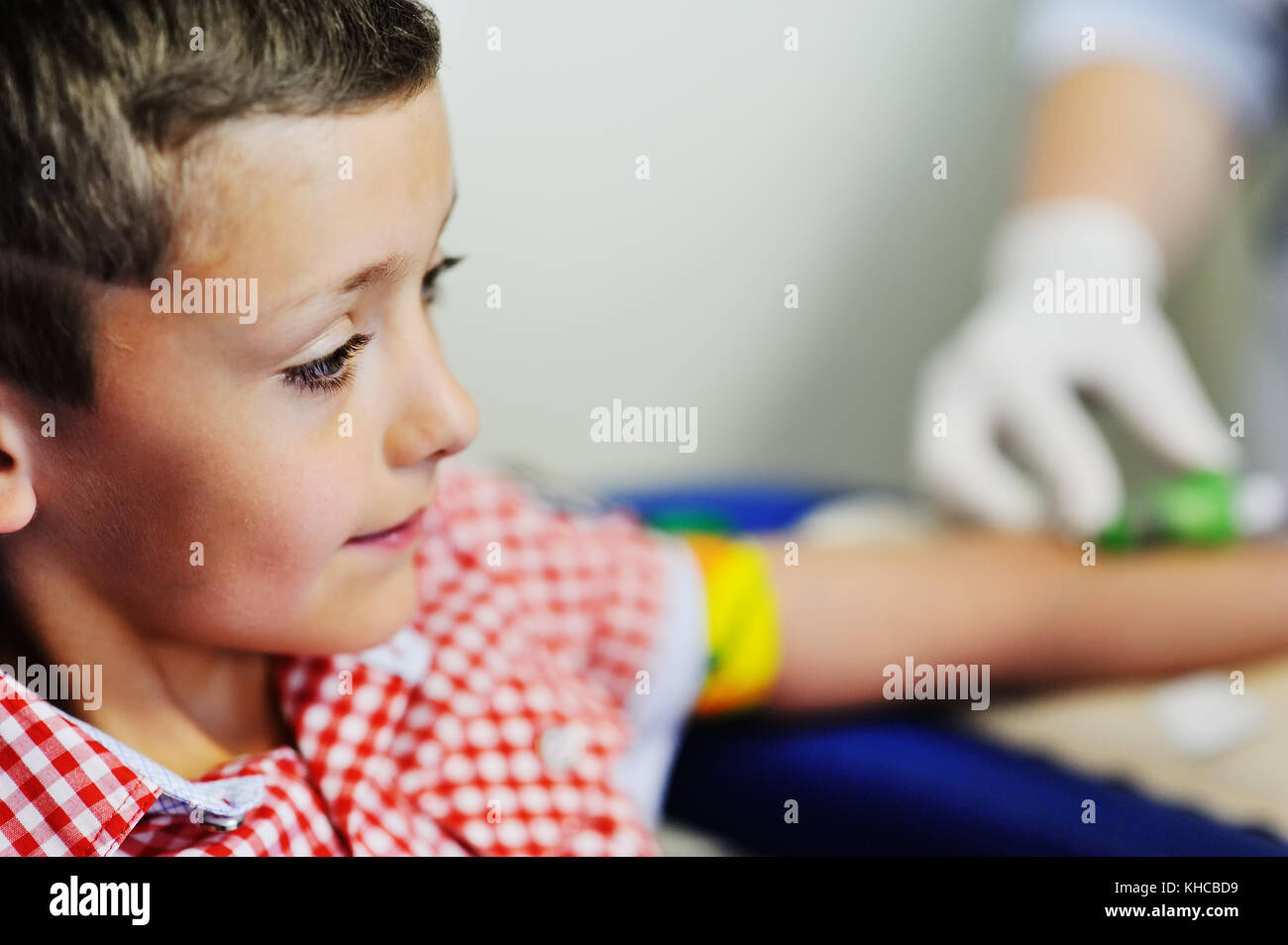 a doctor or nurse takes blood from a vein in a child of a boy Stock ...