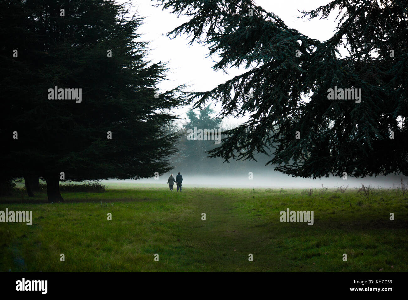 Couple on a walk around fields with low lying mist across fields during ...