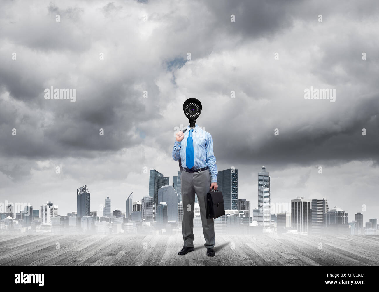 Camera headed man standing on wooden floor against modern cityscape ...