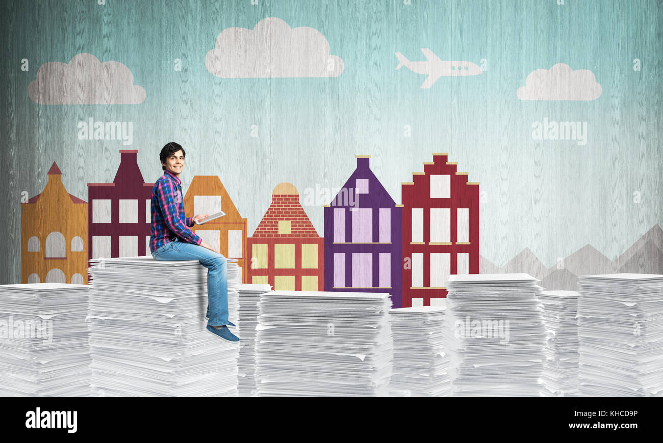 Young man sitting on pile of paper documents Stock Photo - Alamy