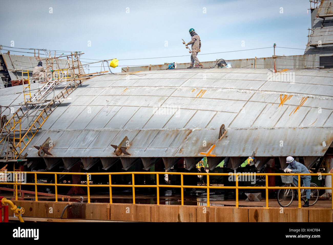 Workers in a dockyard assembling ship blocks. Camranh shipyard. Vietnam ...