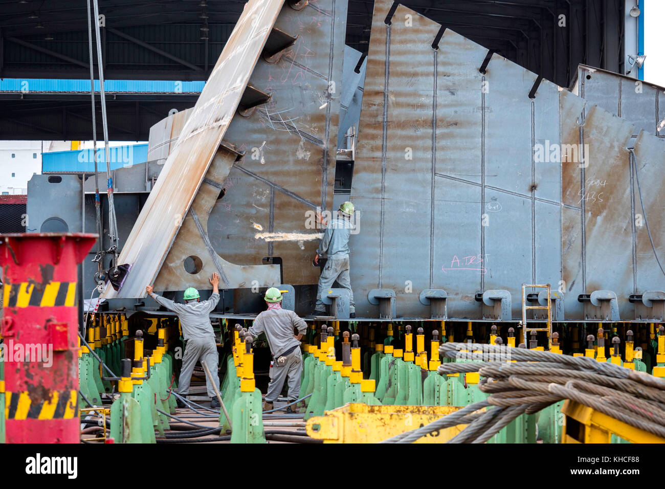 Workers in a dockyard assembling ship blocks. Camranh shipyard. Vietnam ...