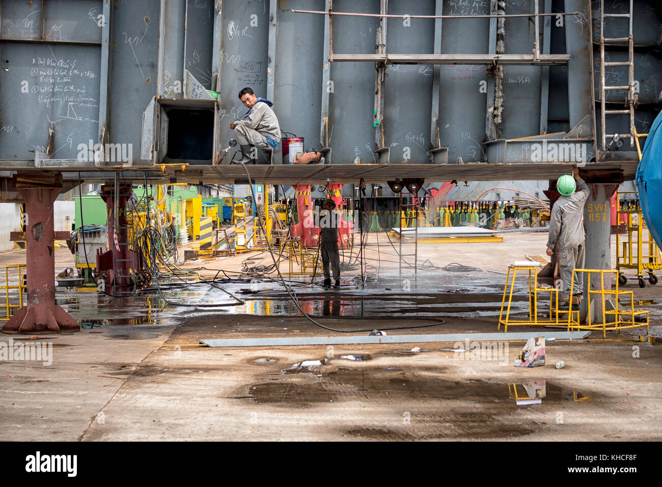 Workers in a dockyard assembling ship blocks. Camranh shipyard. Vietnam ...