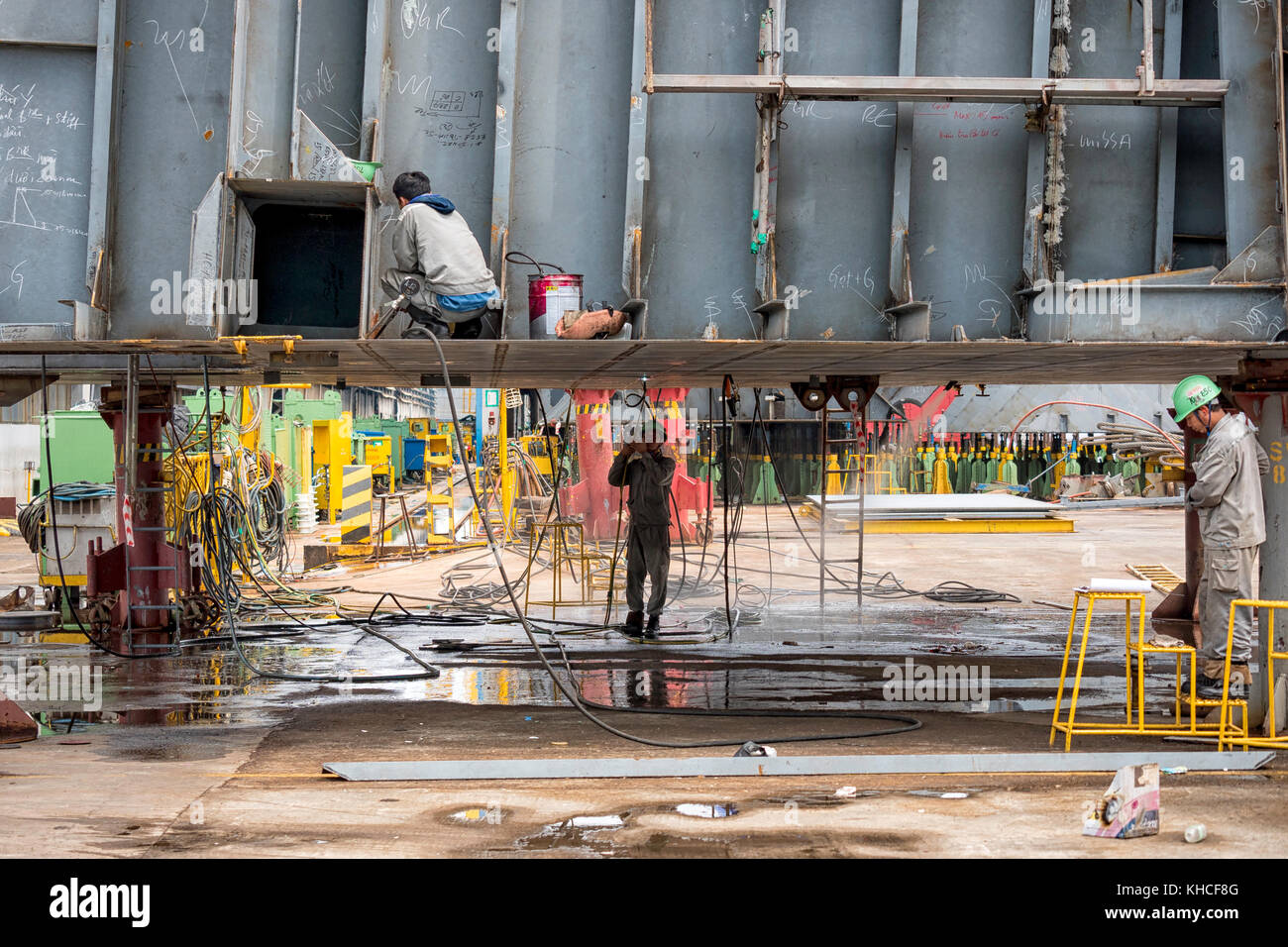 Workers in a dockyard assembling ship blocks. Camranh shipyard. Vietnam ...