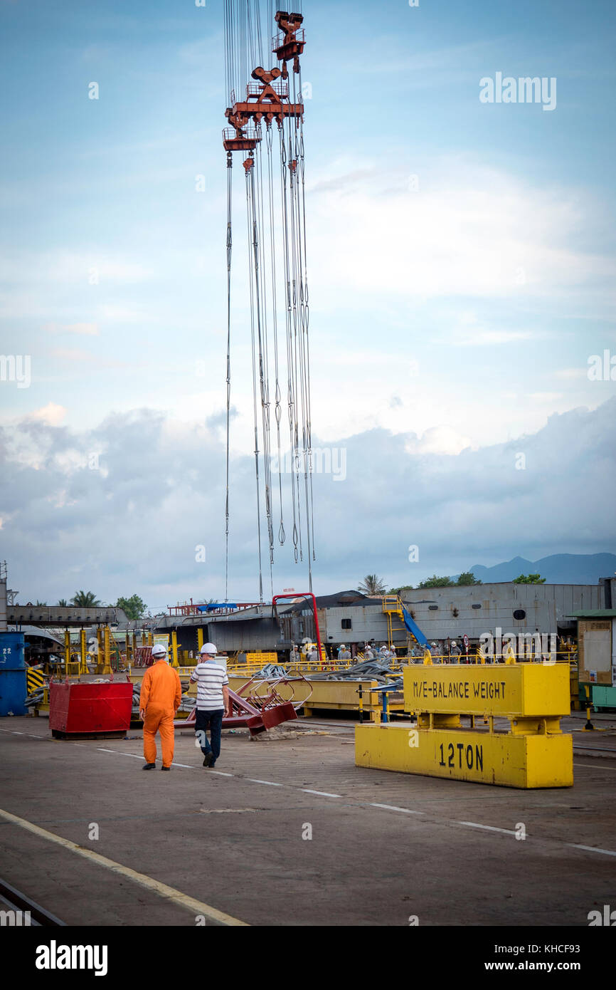 Two engineers walking alongside ship blocks in dockyard. Camranh ...