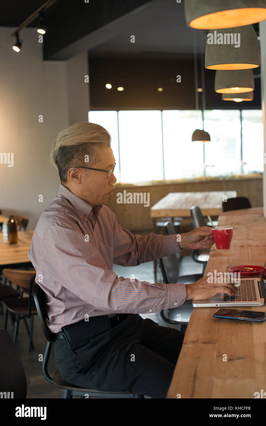 asian senior man using laptop Stock Photo - Alamy