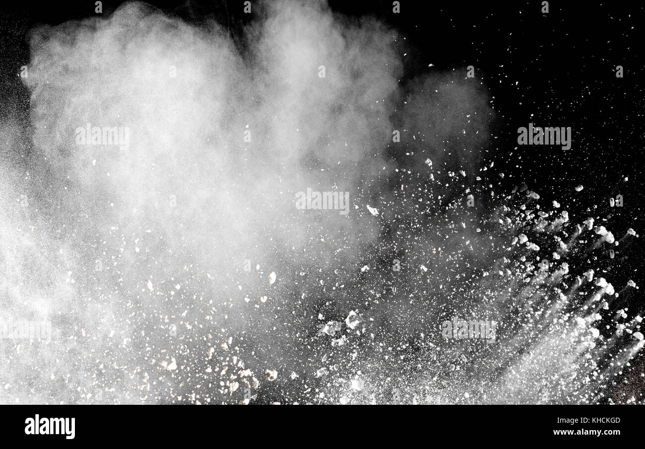 Launched white powder splash on black background Stock Photo - Alamy