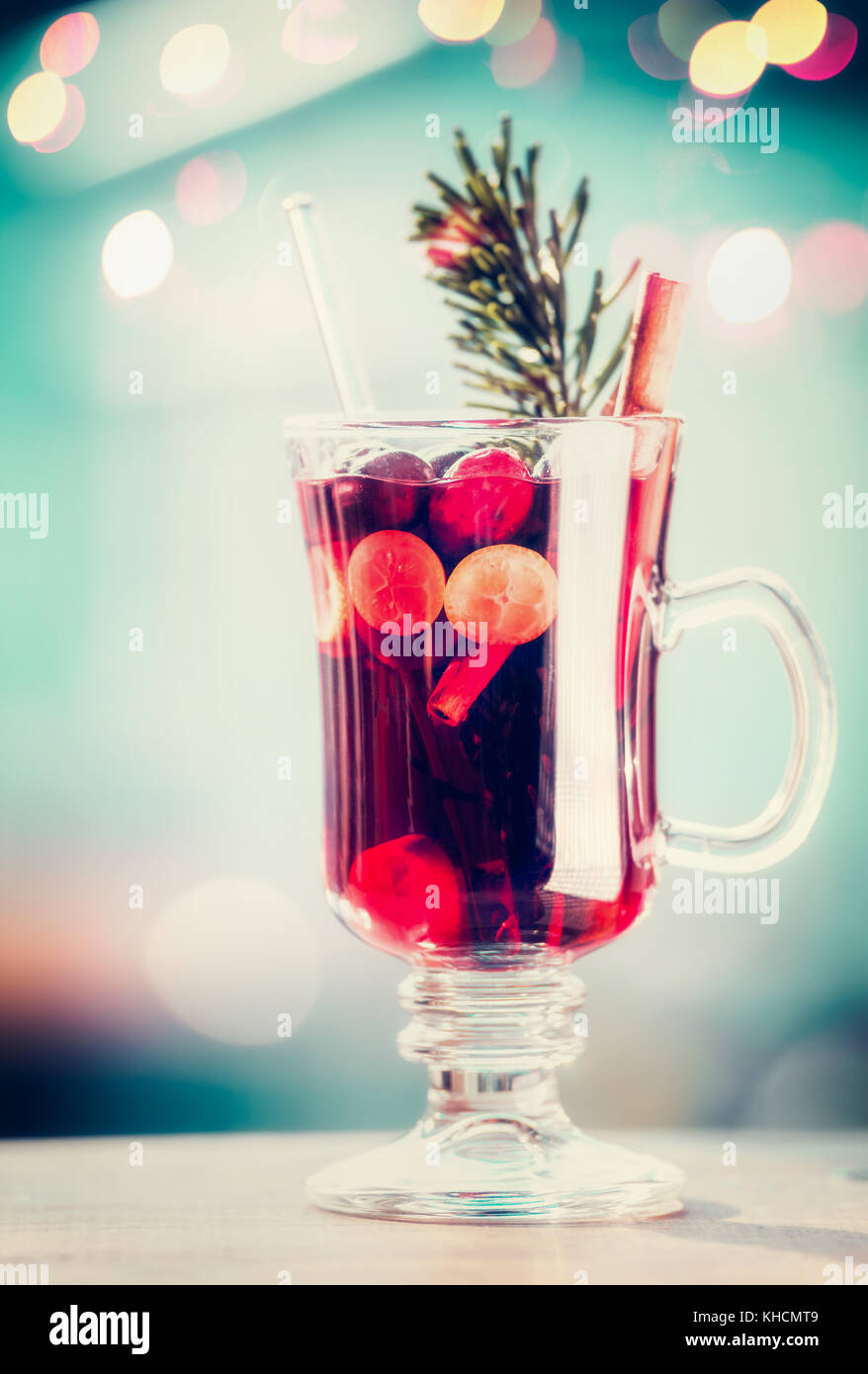 Glass of spiced mulled wine with berries and fir branch on table at ...