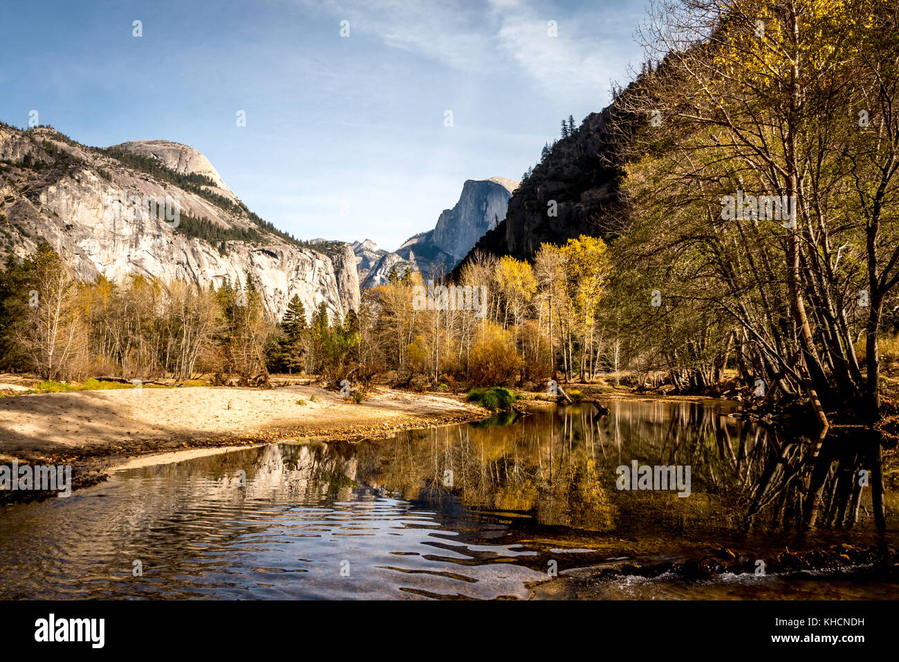 A calm Merced River reflects yellow leaves of autumn in Yosemite Valley ...