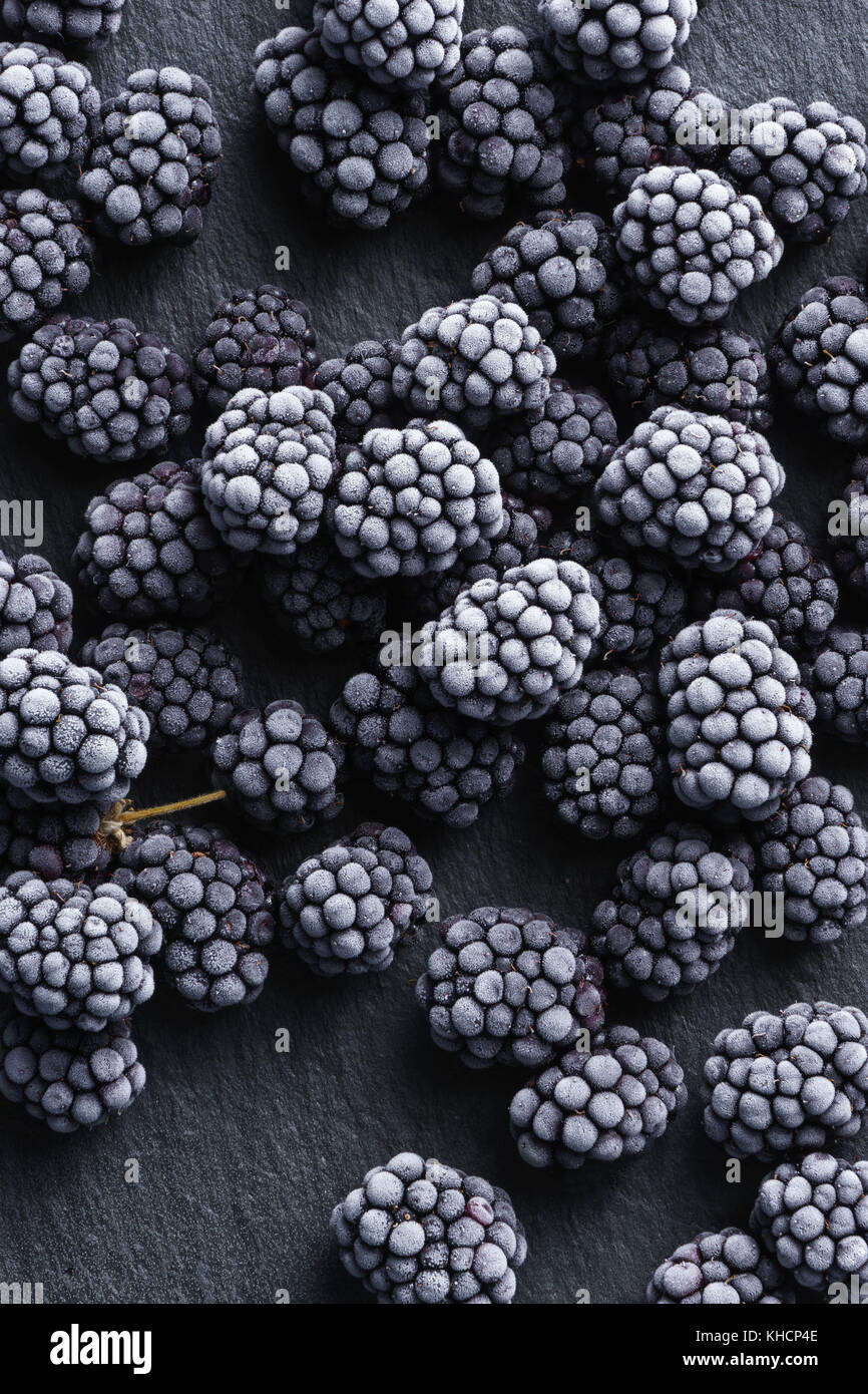 Frozen blackberry on black slate. Top view. High resolution product ...