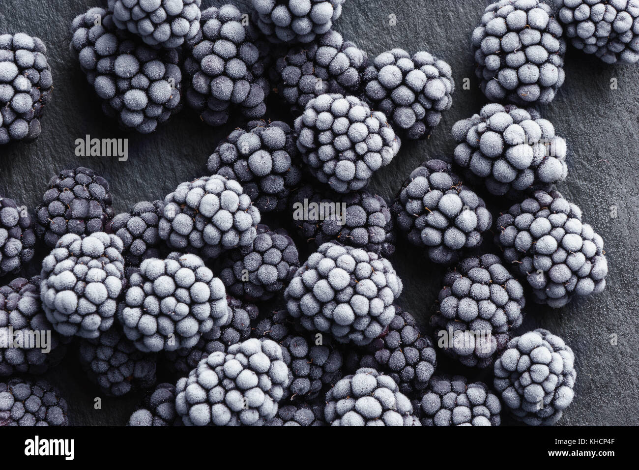 Frozen blackberry on black slate. Close up. Top view. High resolution ...