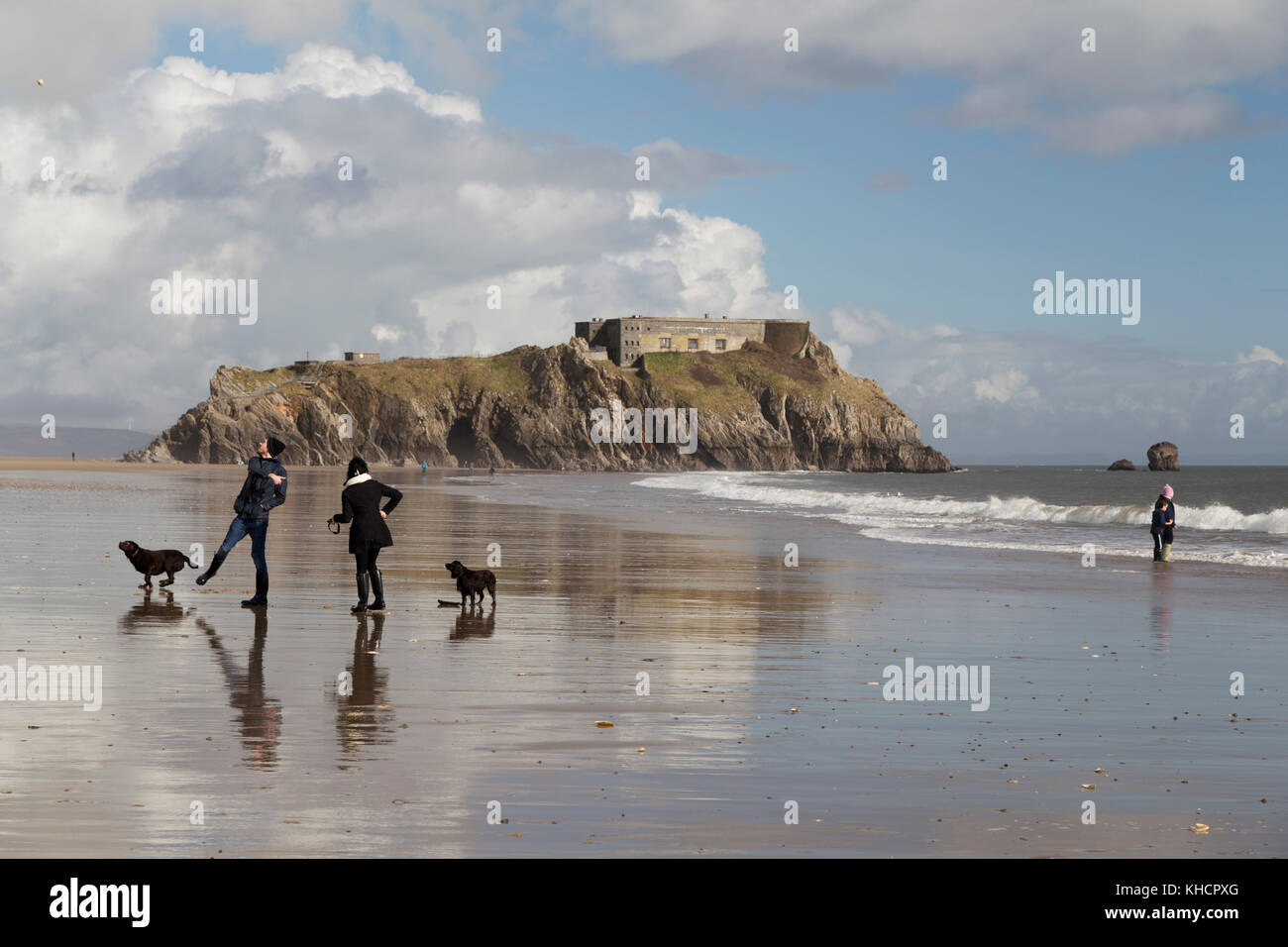 UK, Wales, Tenby, dog walkers enjoying the beach with St Catherine's ...