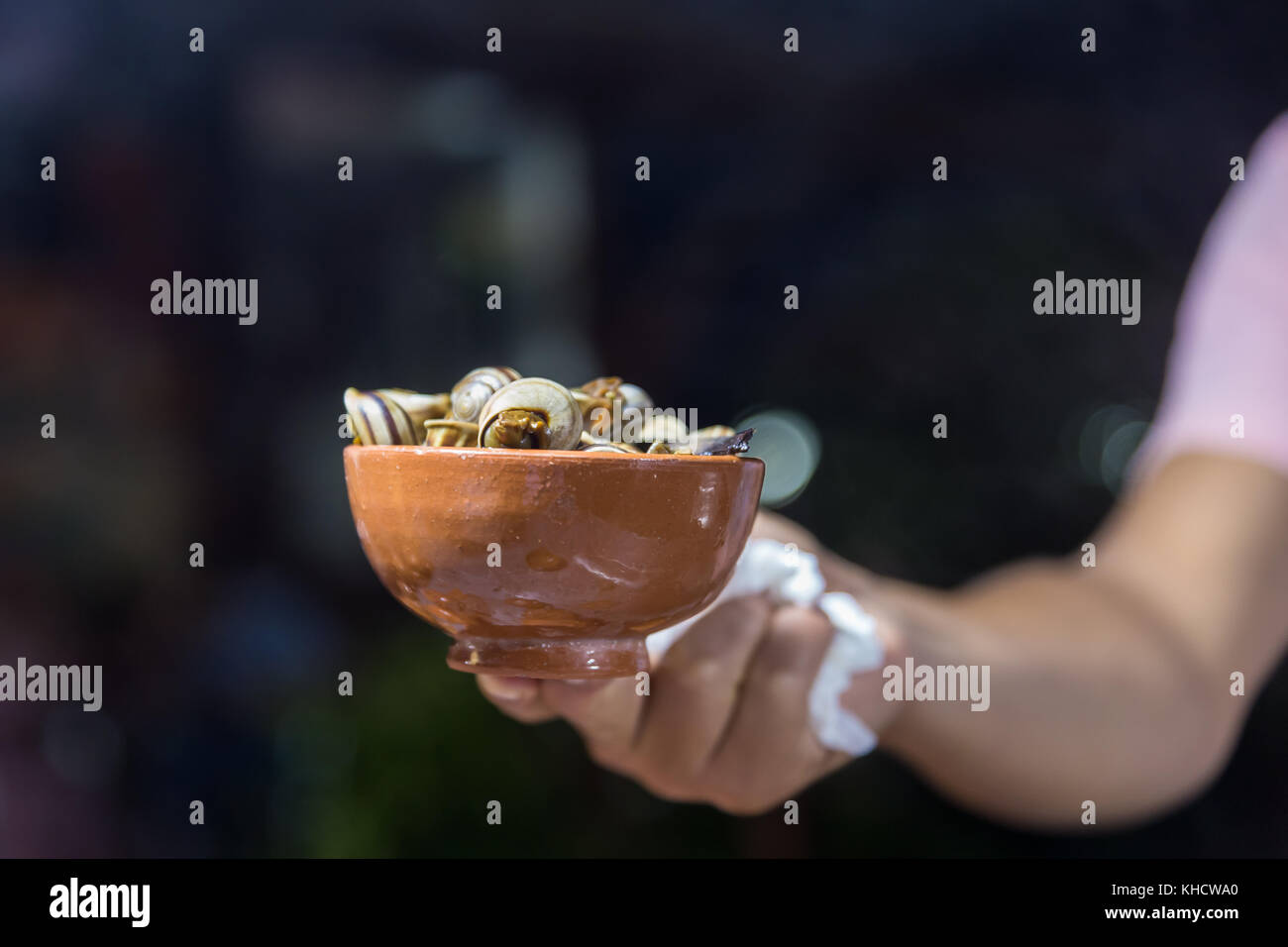 Man holding cooked snails in Morocco at night Stock Photo - Alamy