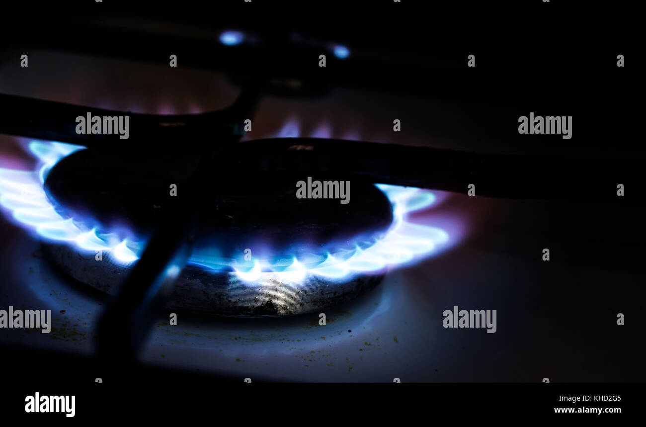 Blue gas burning from old kitchen gas stove on black background in ...