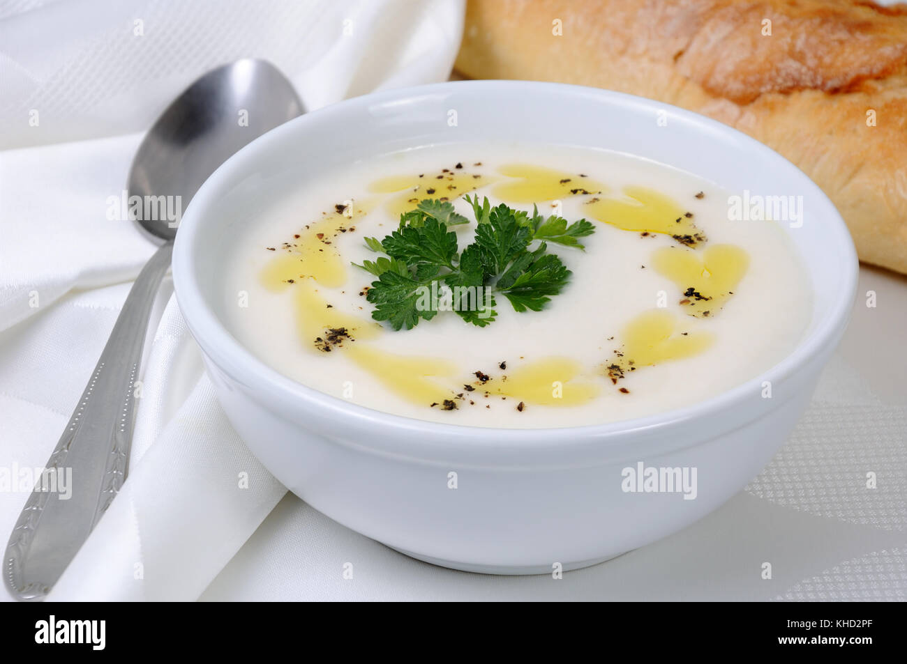 A bowl of white bean puree soup with spicy butter and spices, herb ...