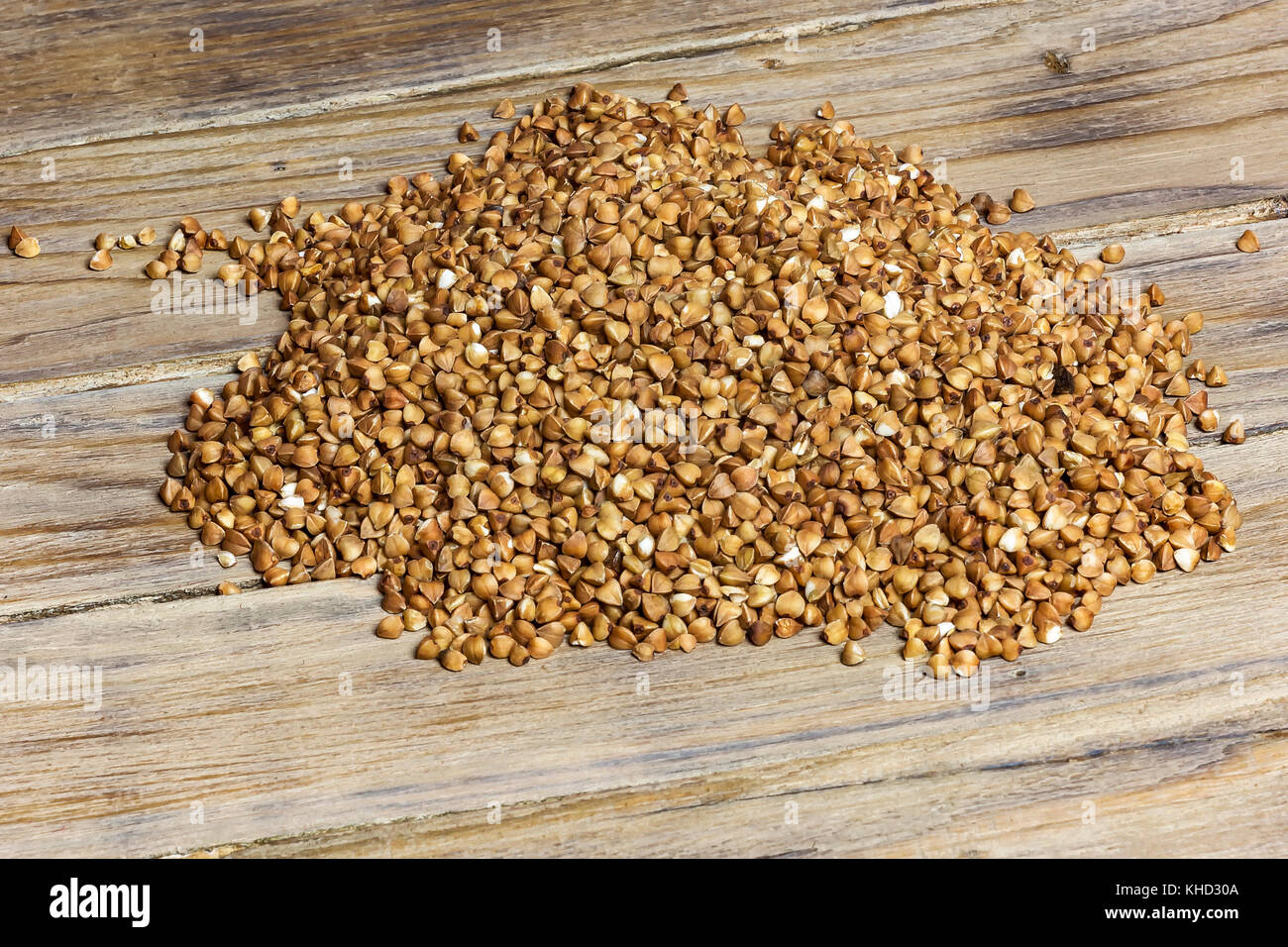 On the wooden surface are scattered seeds of buckwheat groats Stock ...