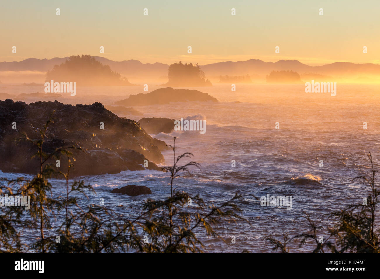 Mist from Pacific Ocean waves breaking over rugged islands off-shore ...