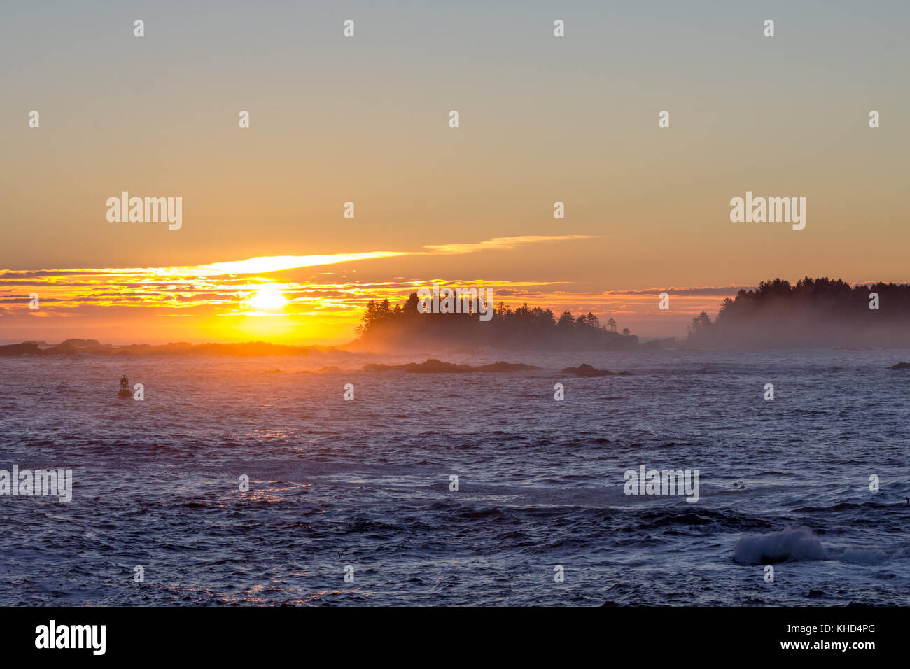 Bright sun rises just over the horizon casting an orange glow and back ...