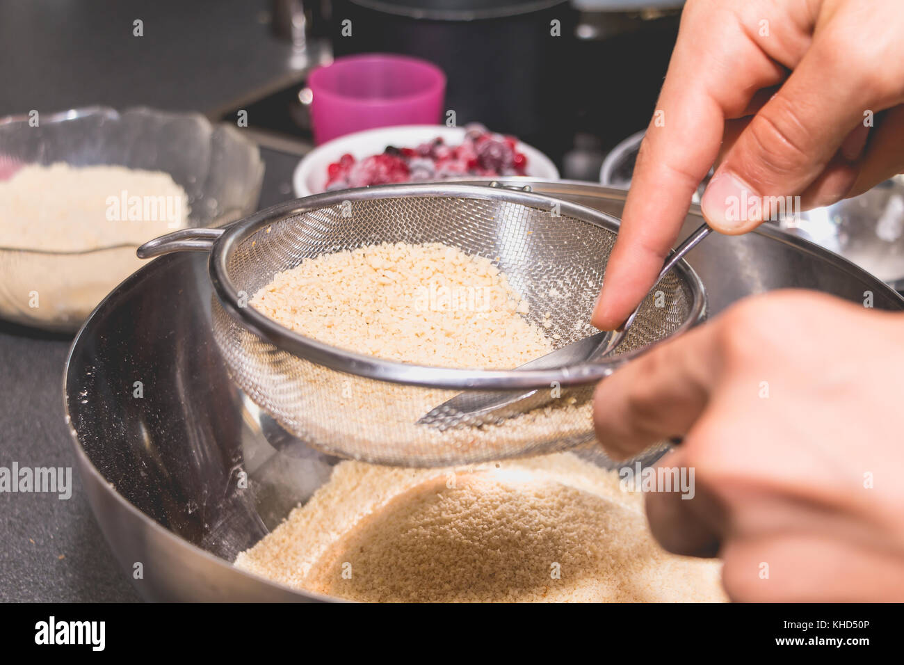 cook mixes and sieves almond powder in flour in the macaroons recipe ...
