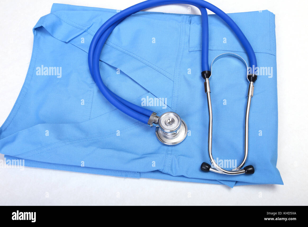 Medical stethoscope head lying on blue doctor uniform closeup. Medical ...