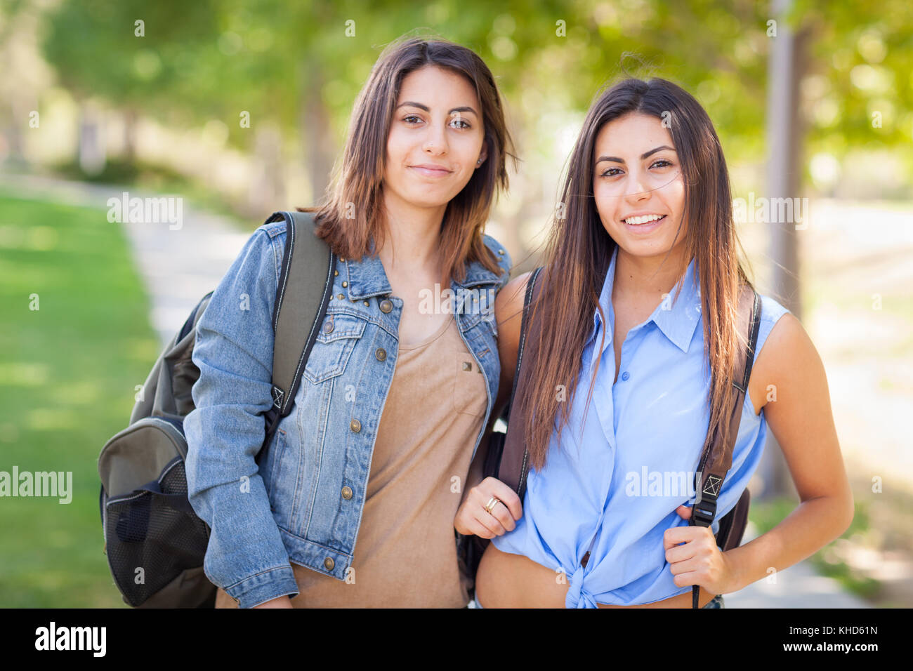 Two Beautiful Young Ethnic Twin Sisters With Backpacks Walking Outdoors ...
