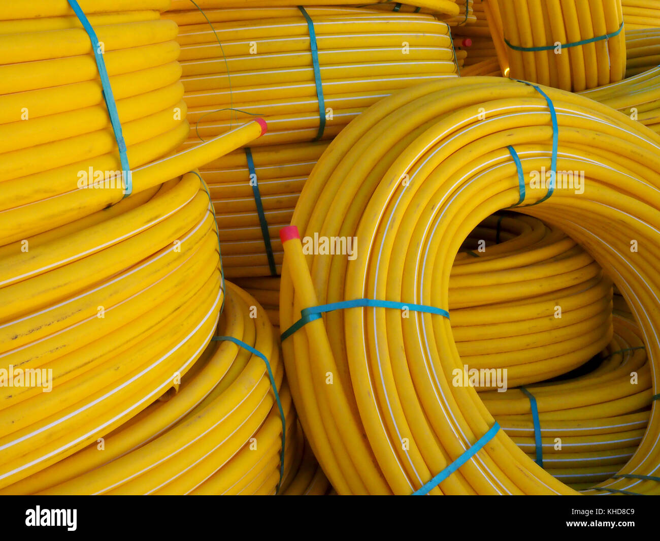 Bright yellow electric cable is connected to huge bobbins, drawn by a ...