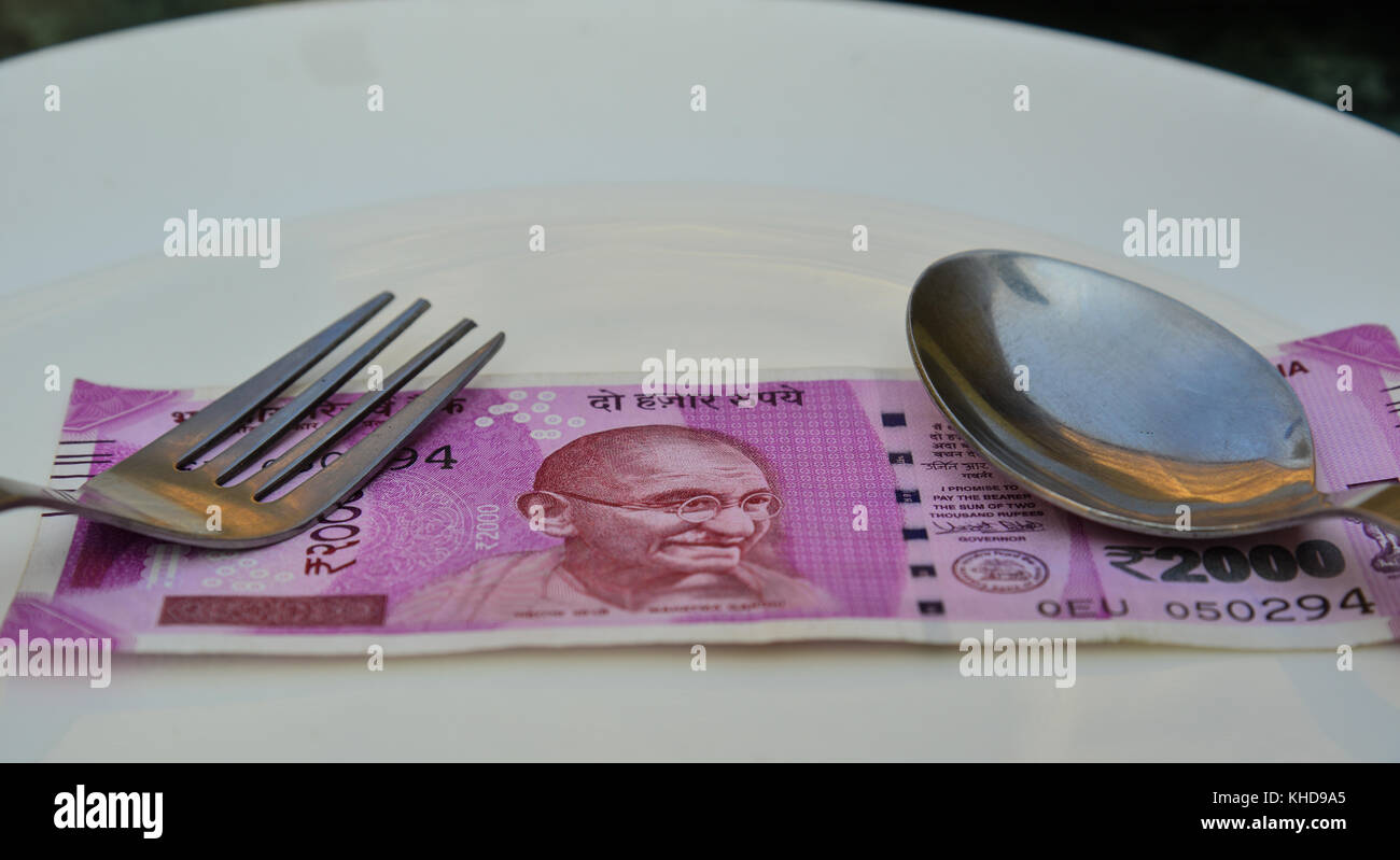 A new Indian currency note of 2000 rupees on white dish at restaurant ...