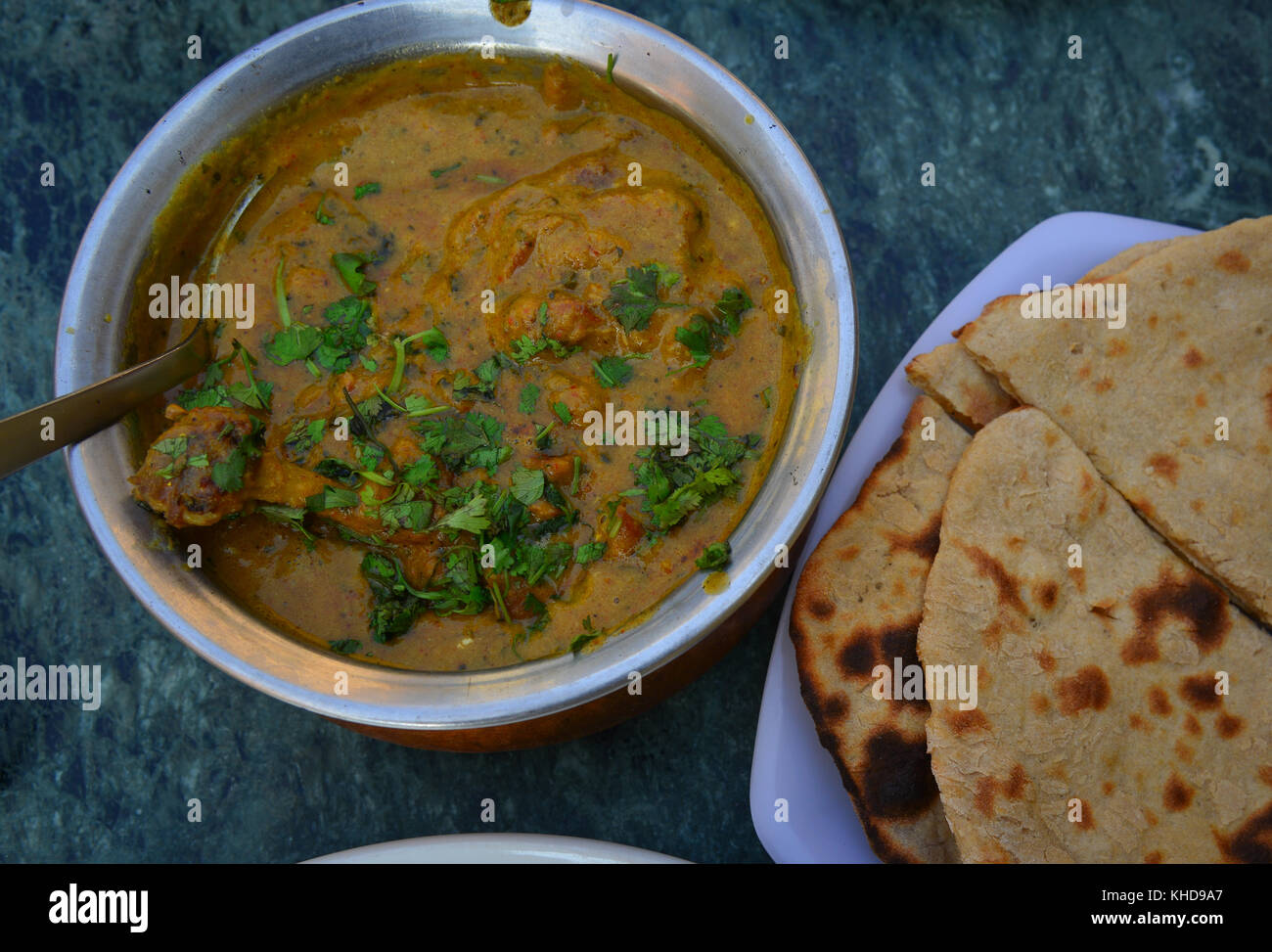 Butter chicken curry with Indian bread (roti) on table at local ...