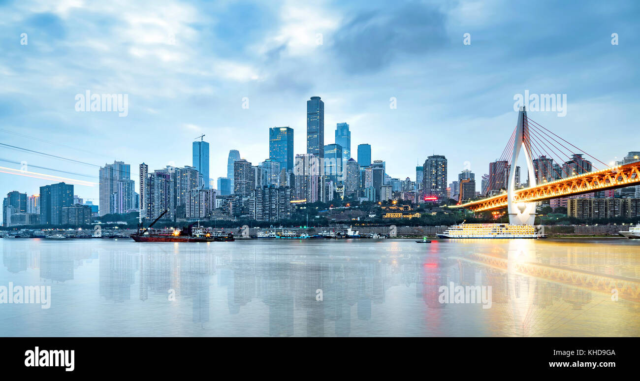 cityscape and skyline of downtown near water of chongqing at night ...