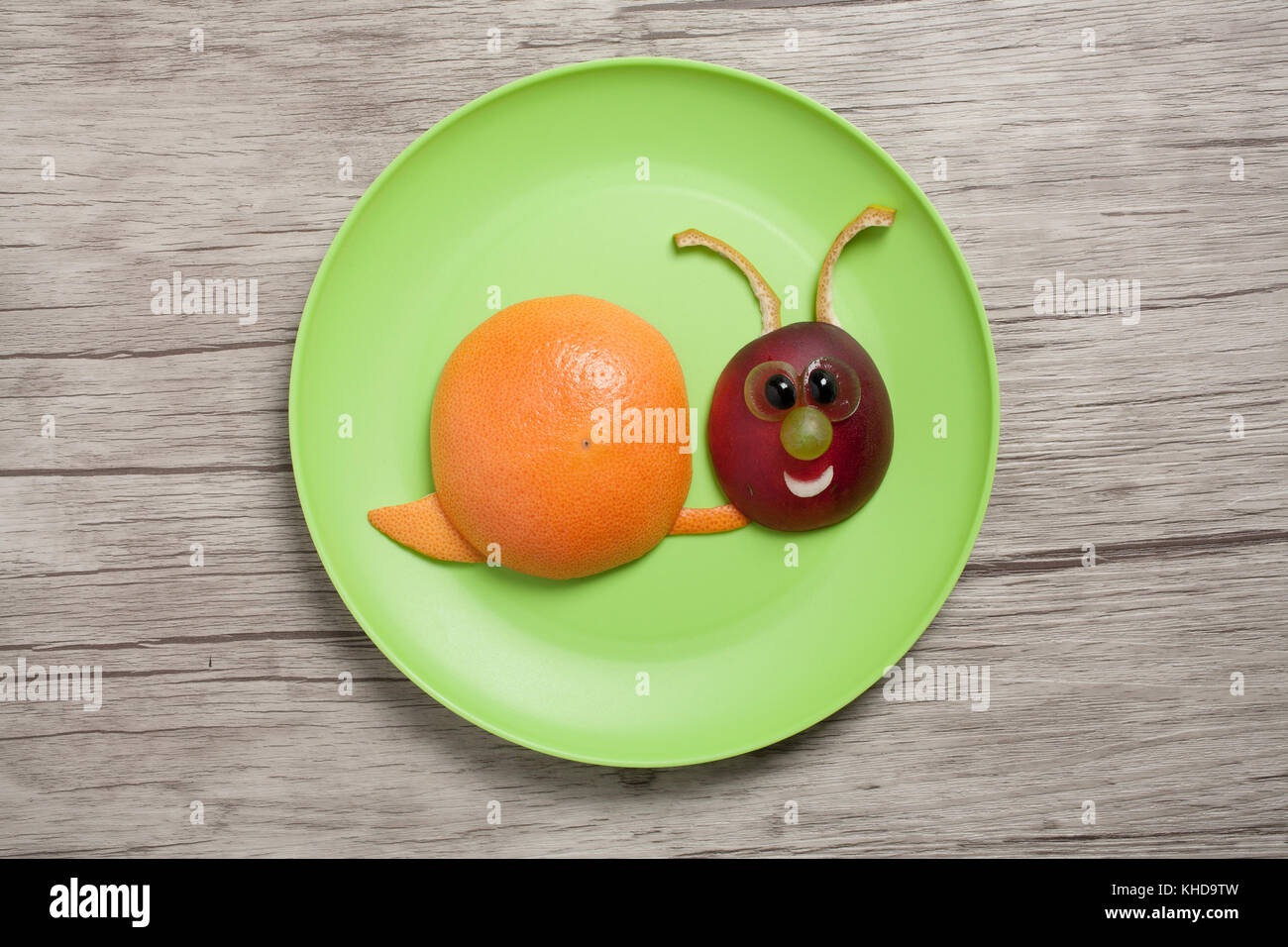 Snail made with fruits on plate and table Stock Photo - Alamy