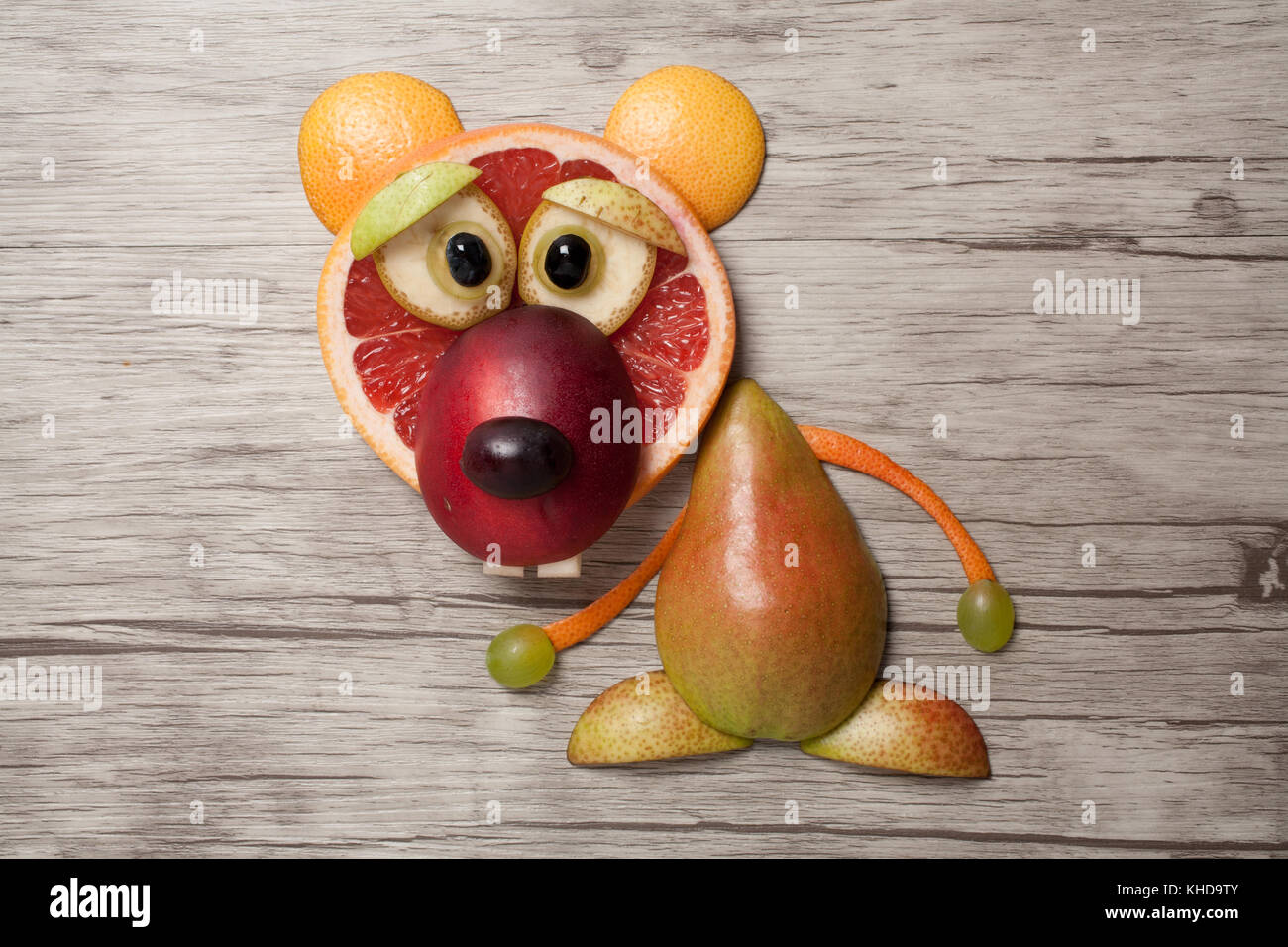 Funny fruit bear made on wooden background Stock Photo - Alamy