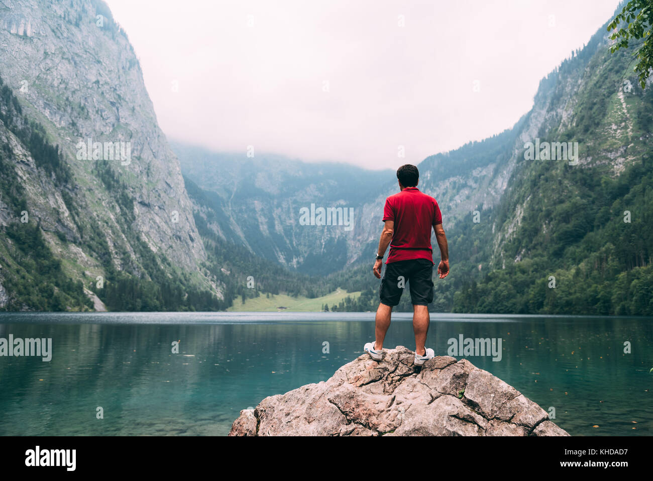 Man standing on rock looking at beautiful and misty lake in the Stock ...