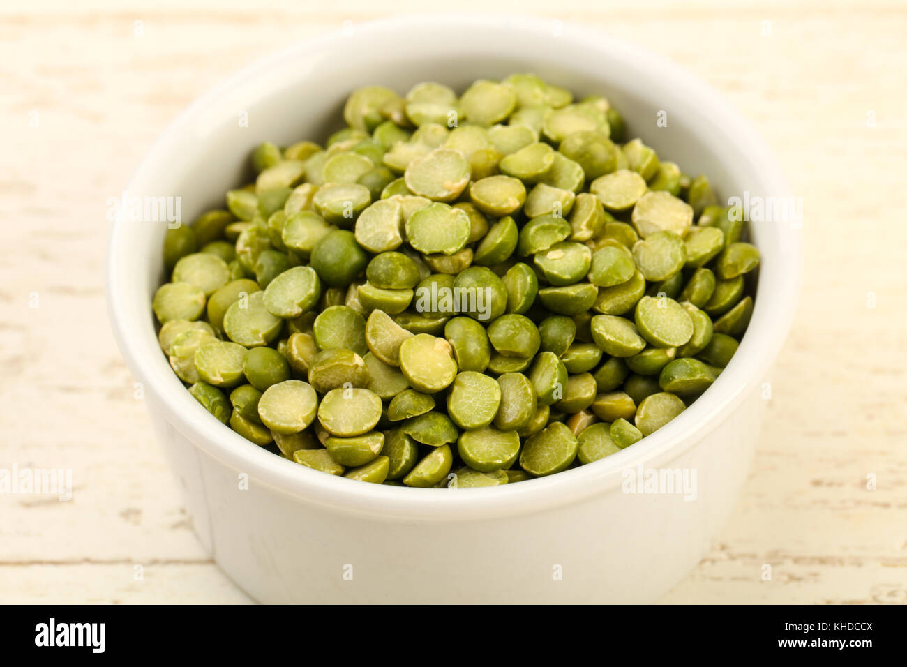 Green peas pile in the bowl over wooden background Stock Photo - Alamy