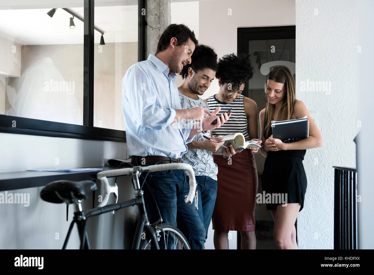 Group of friends standing around chatting Stock Photo - Alamy