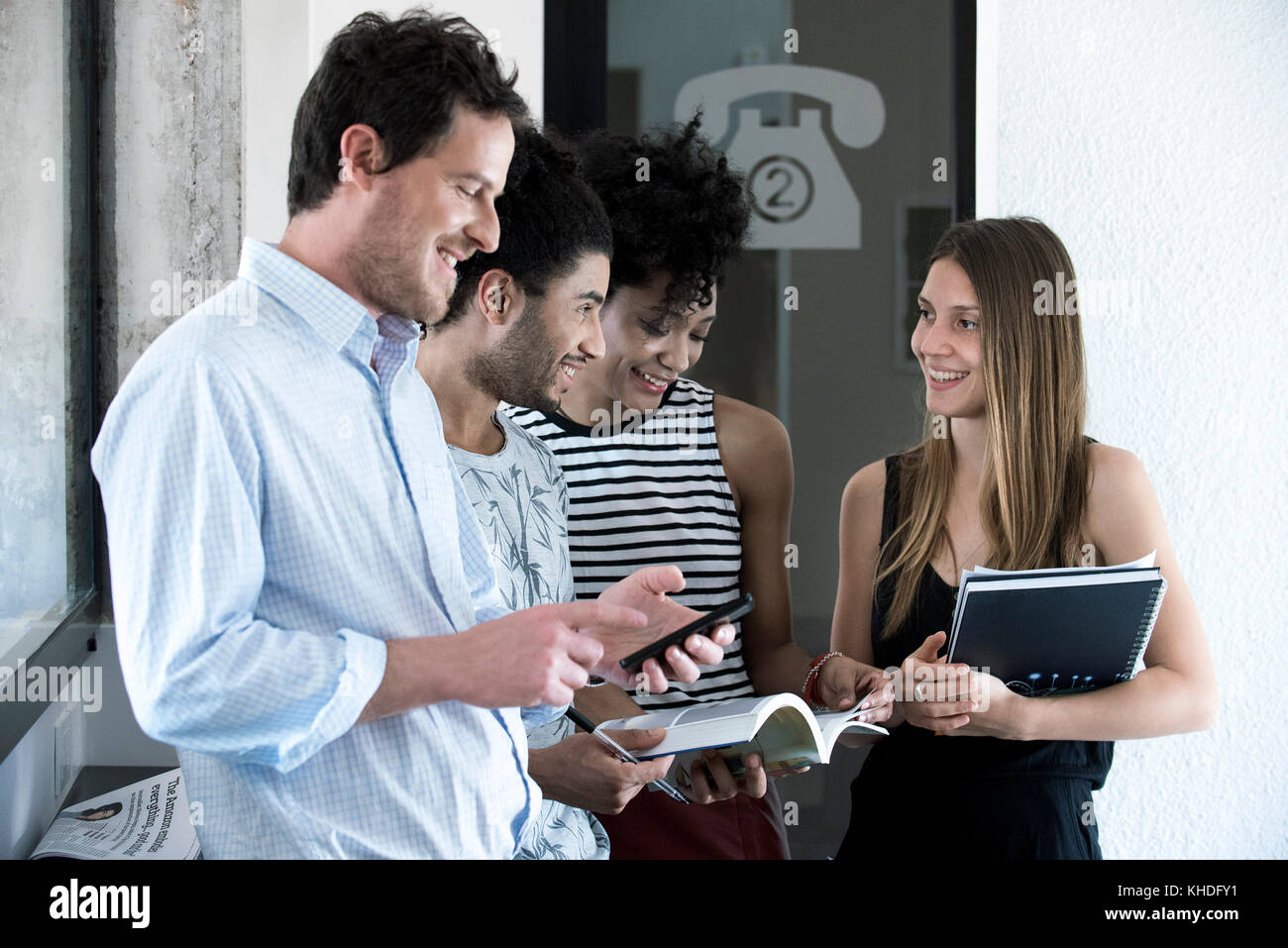 Group of friends standing around chatting Stock Photo - Alamy