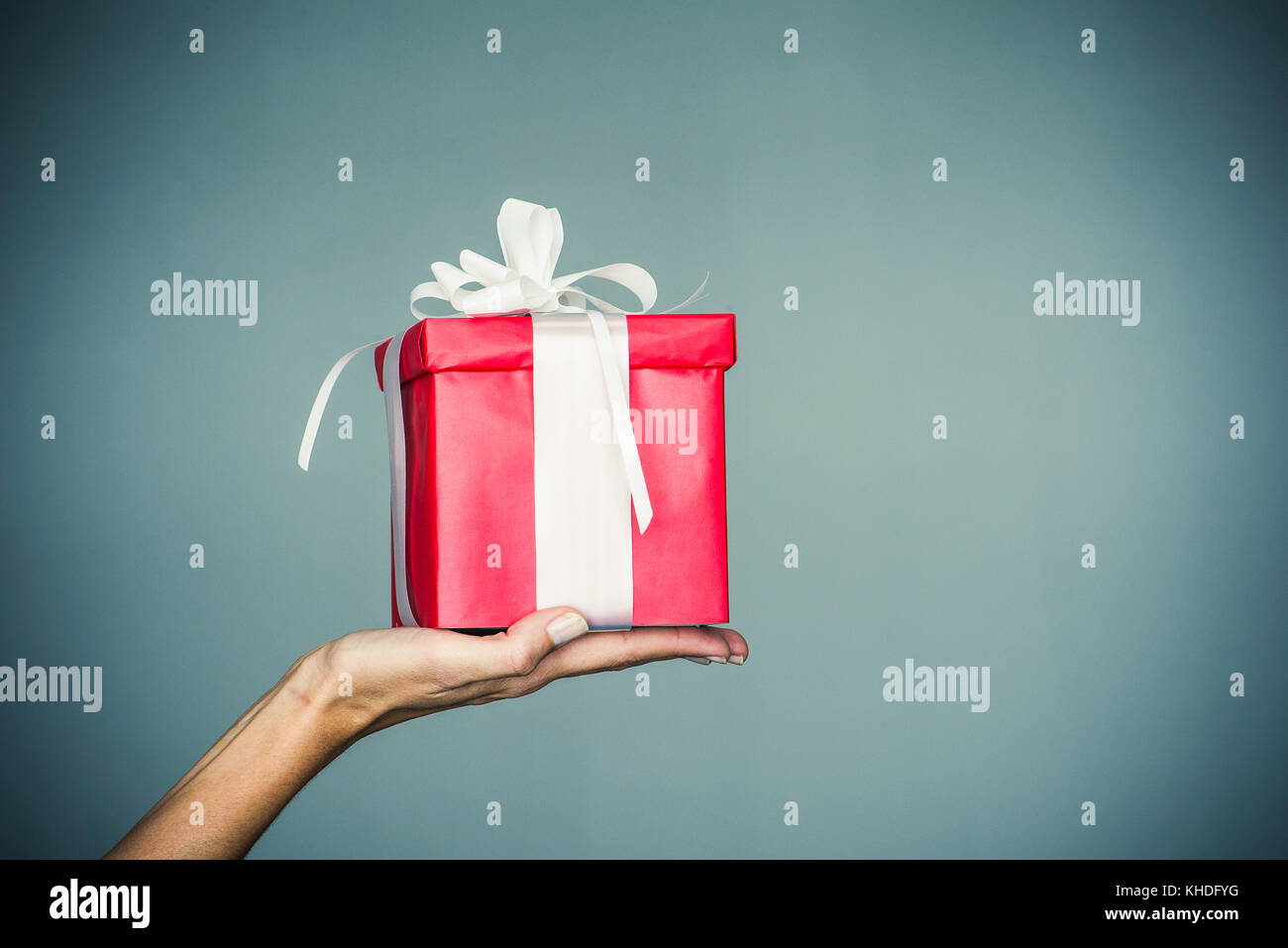 Woman's hand holding wrapped gift Stock Photo - Alamy