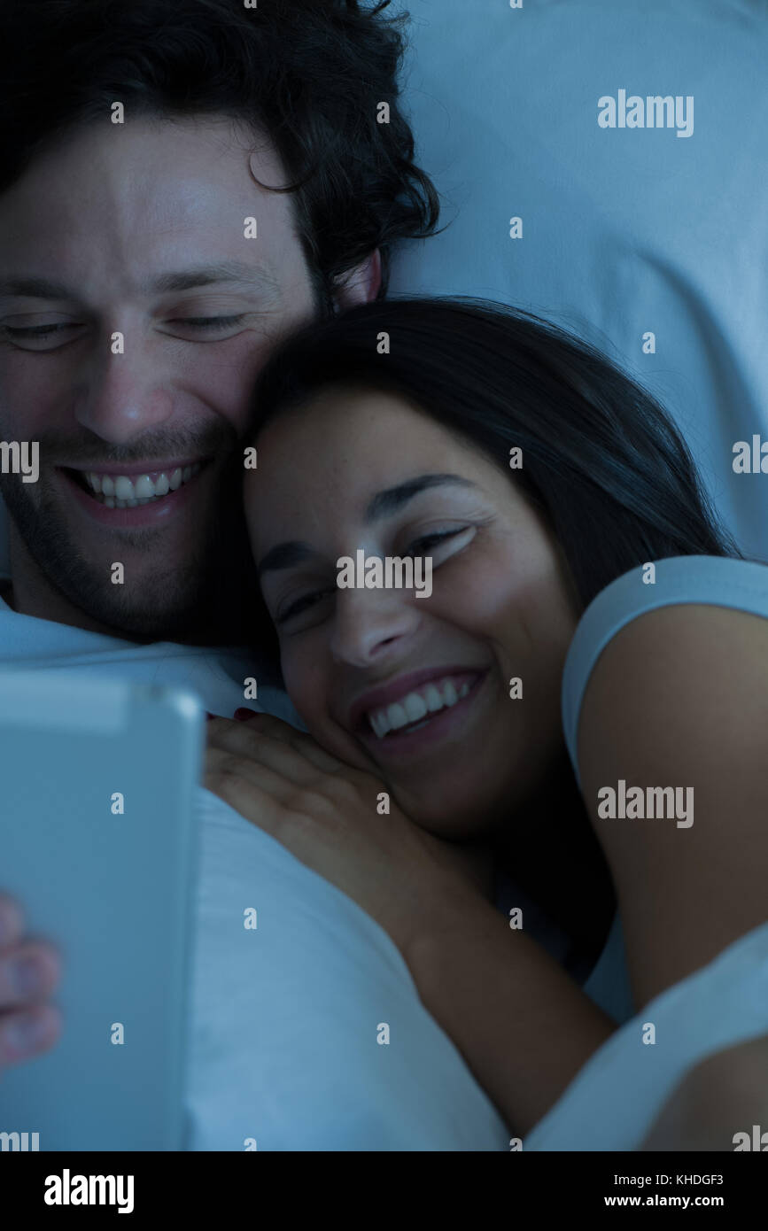Couple using digital tablet in bed Stock Photo - Alamy