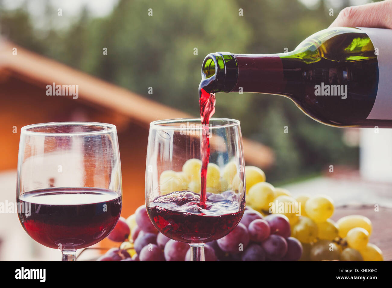 close up of red wine being poured from bottle to glass Stock Photo - Alamy