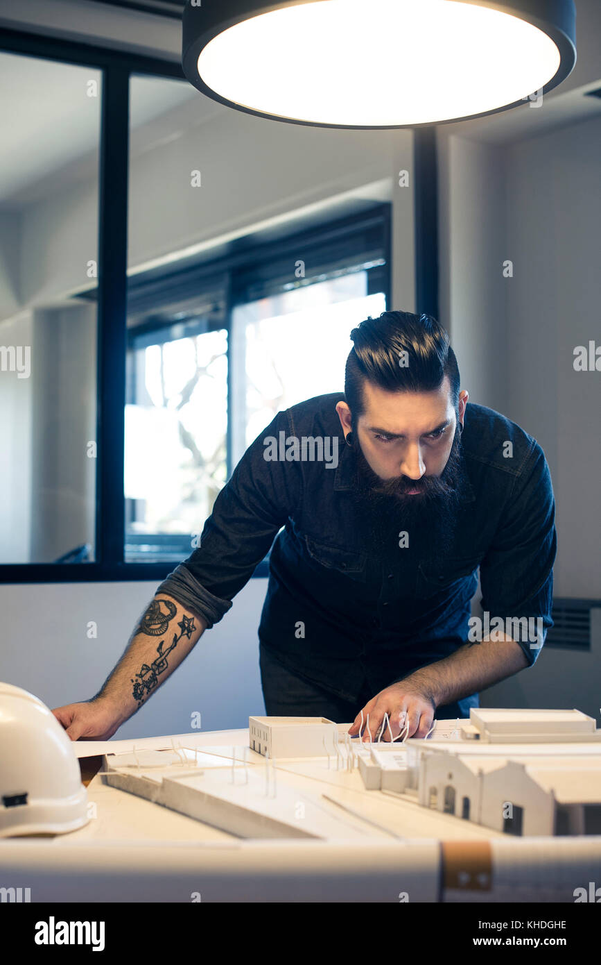 Architect looking at model building in office Stock Photo - Alamy