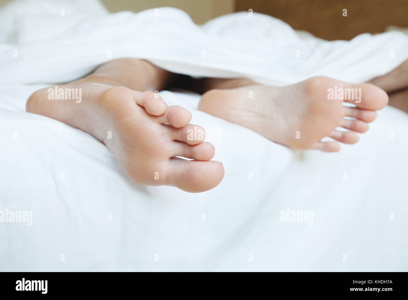 sweet sleep on comfortable mattress, feet of person in the bed under ...