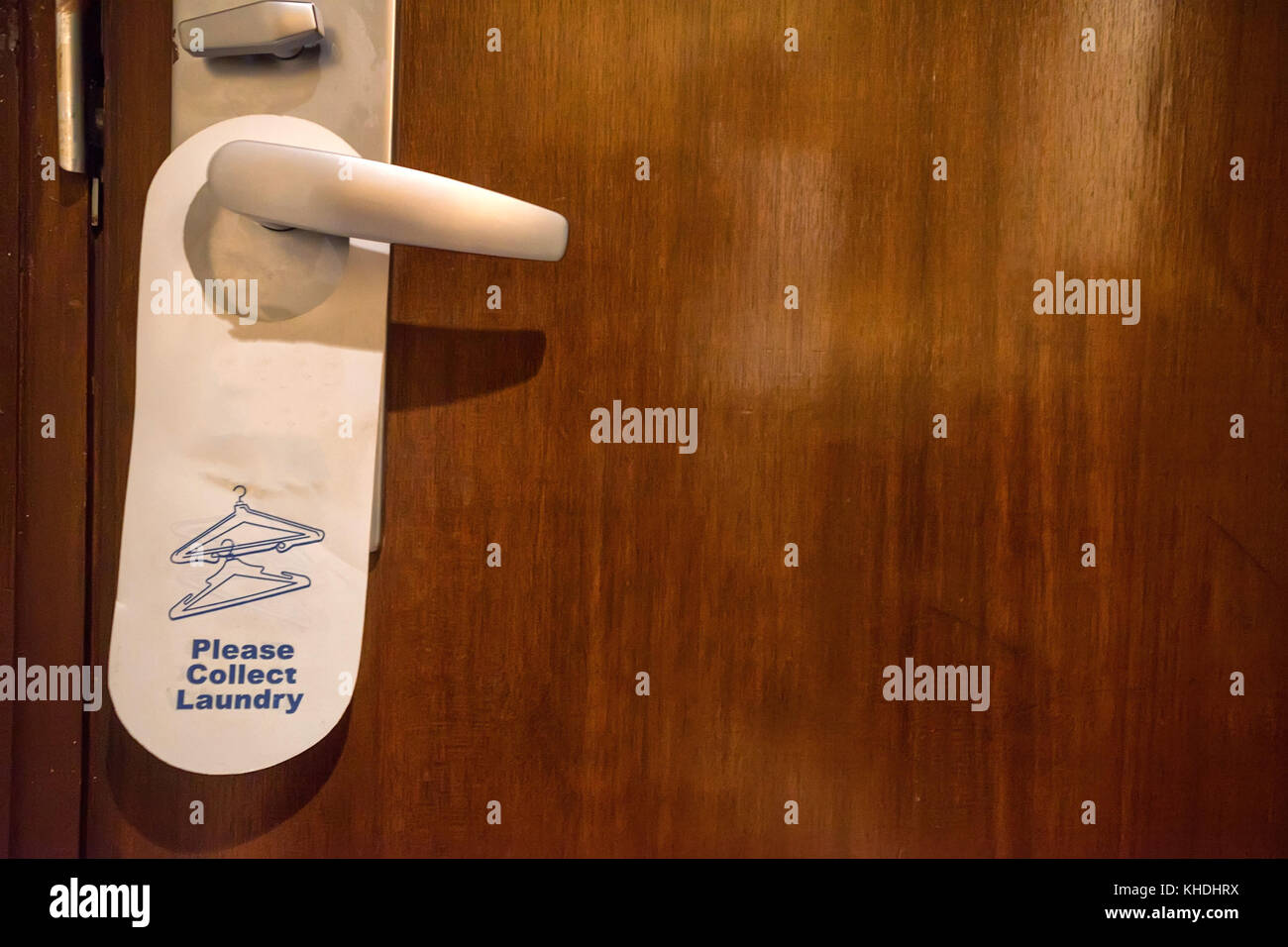 Collect laundry sign on doorknob Stock Photo - Alamy
