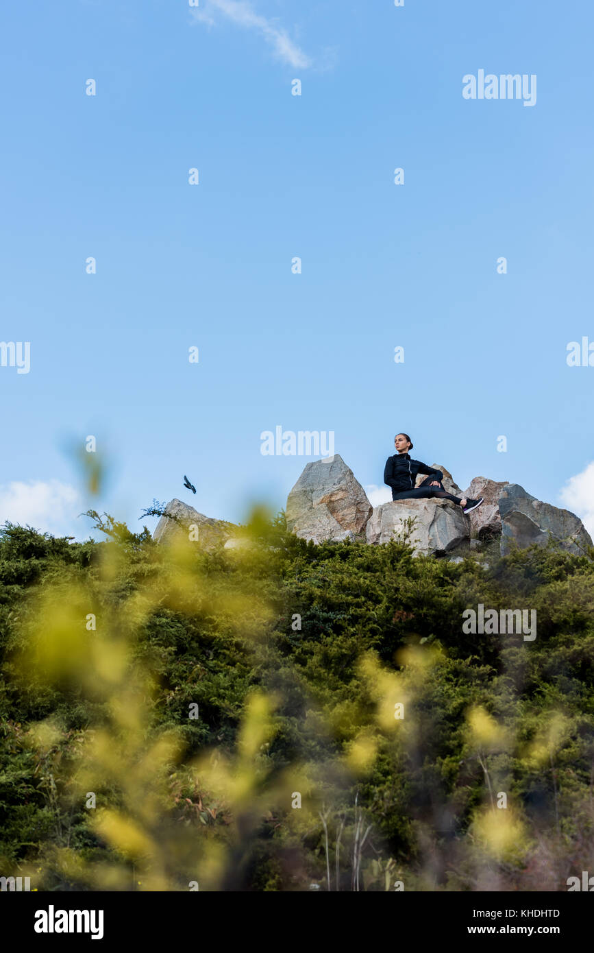 woman sitting on rocks Stock Photo - Alamy