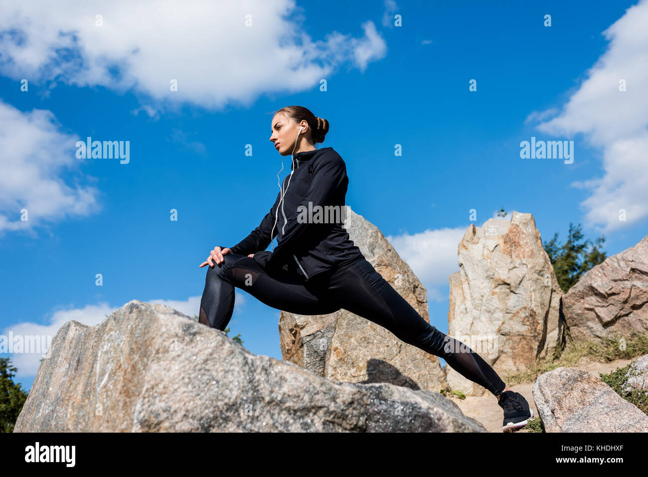 woman stretching legs on rocks Stock Photo - Alamy