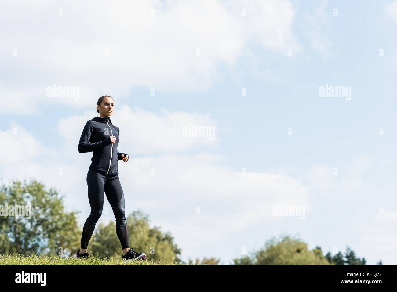 woman jogging on grass field Stock Photo - Alamy