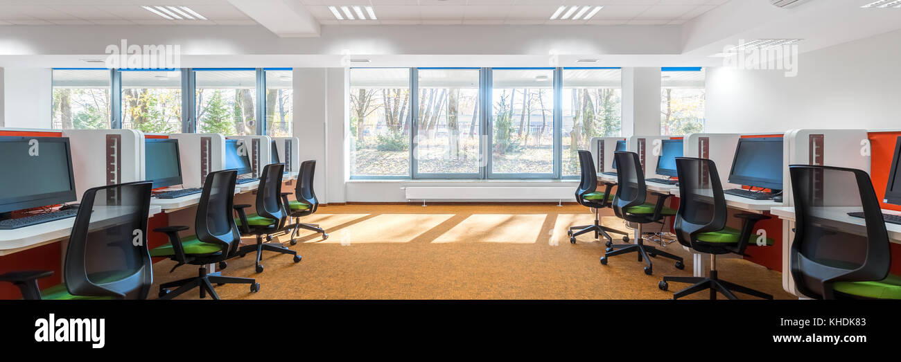Panoramic view of spacious IT classroom with orange flooring and window ...