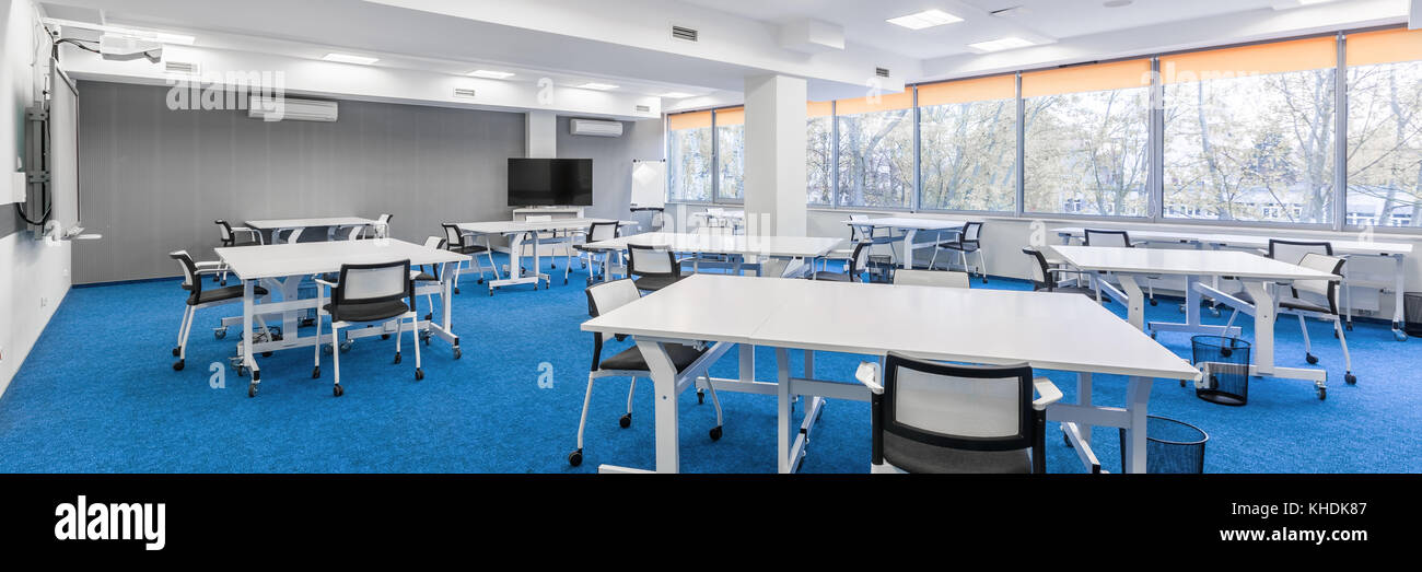 Panoramic view of bright university communal study room with white ...