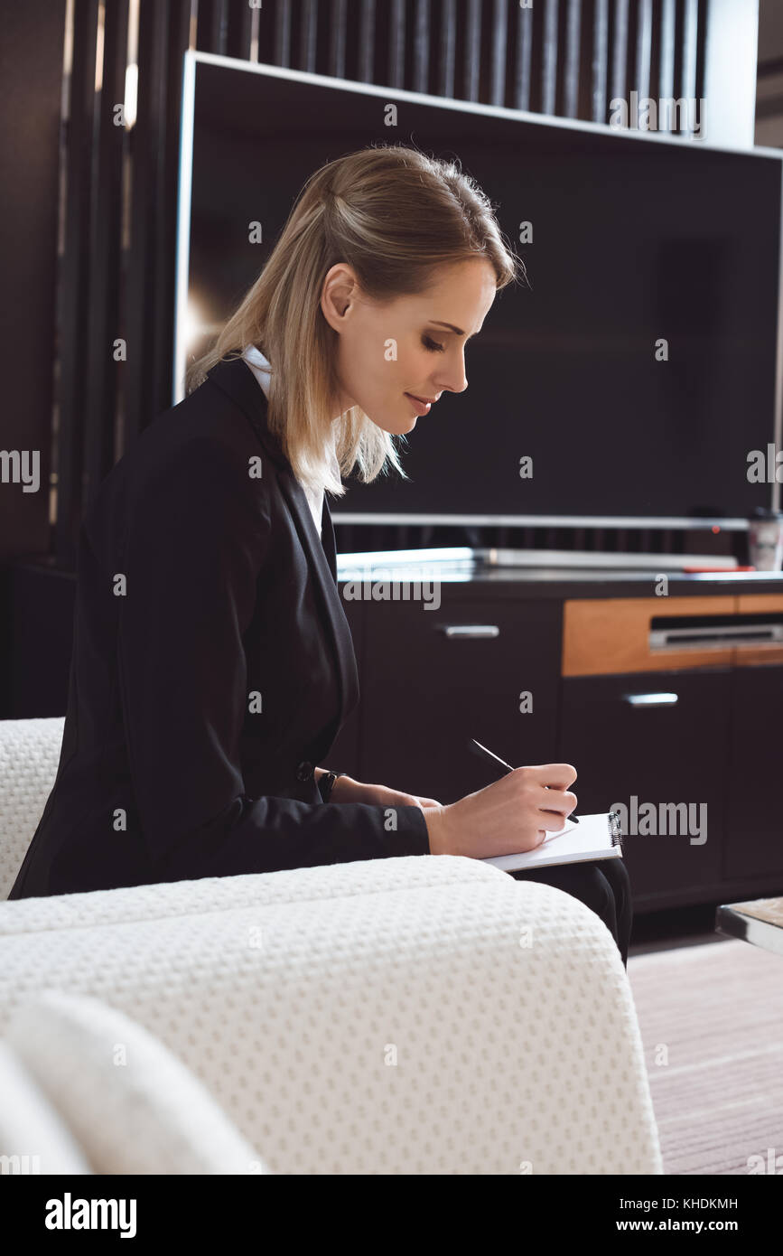 businesswoman taking notes in hotel room Stock Photo - Alamy
