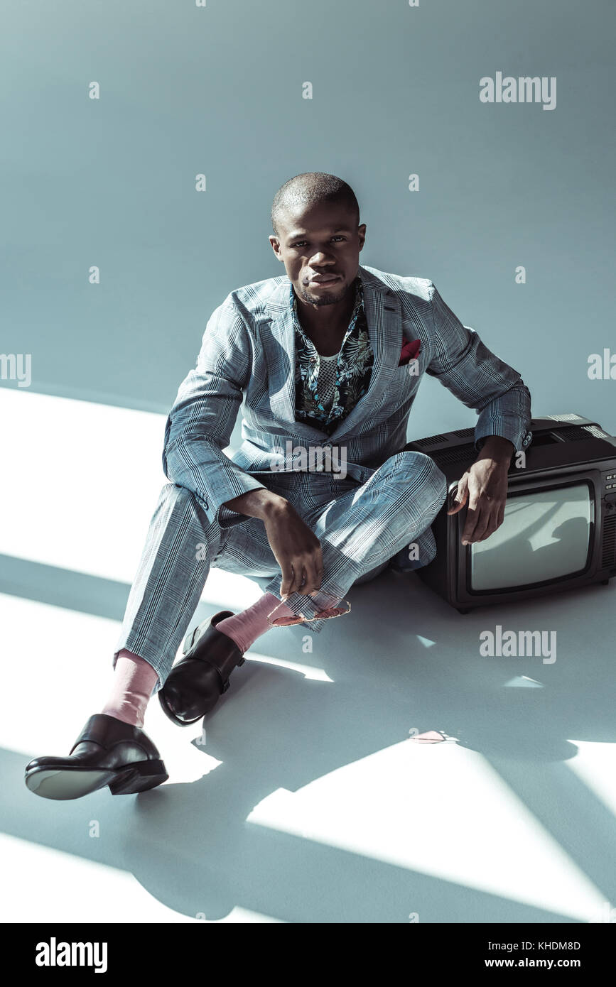 Man in stylish suit posing with tv Stock Photo - Alamy